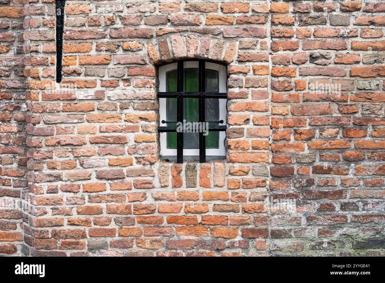 Facade view of window with grating iron on brick wall background ...