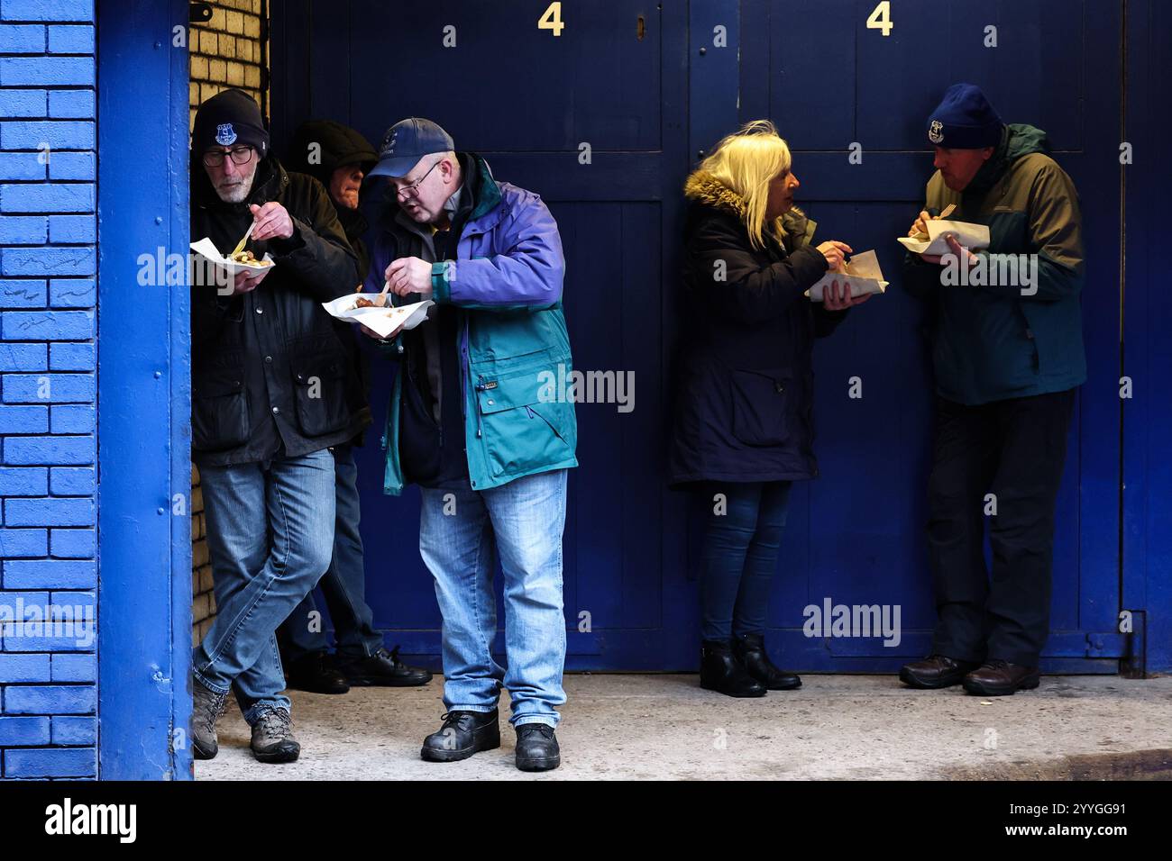 Fans take cover from the rain as they have a bite to eat during the ...
