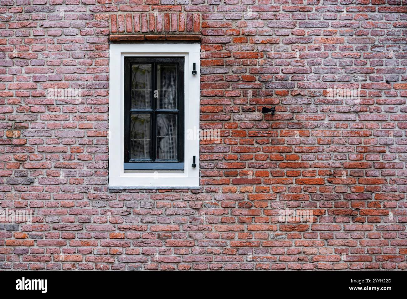 Facade view of window with curtain on brick wall background. Building ...