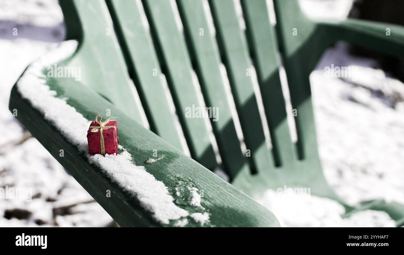 One small red gifts rest on the arm of a green chair covered in fresh ...