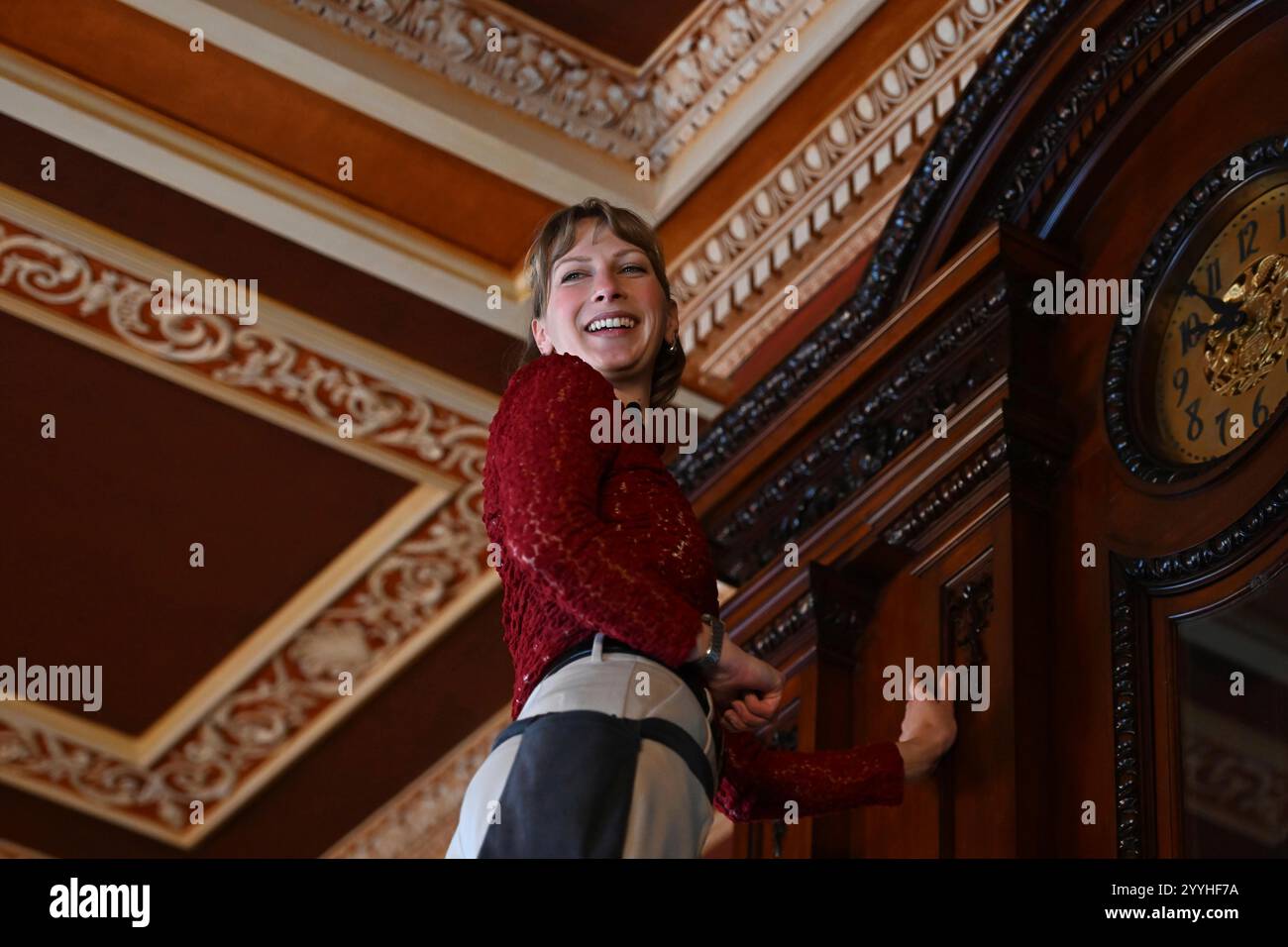 Bethany Gill smiles as she prepares to wind a clock in the office of ...
