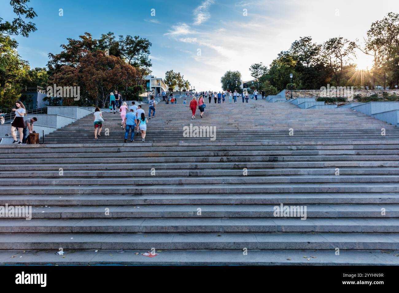 A group of people are walking up a set of stairs. The stairs are very ...