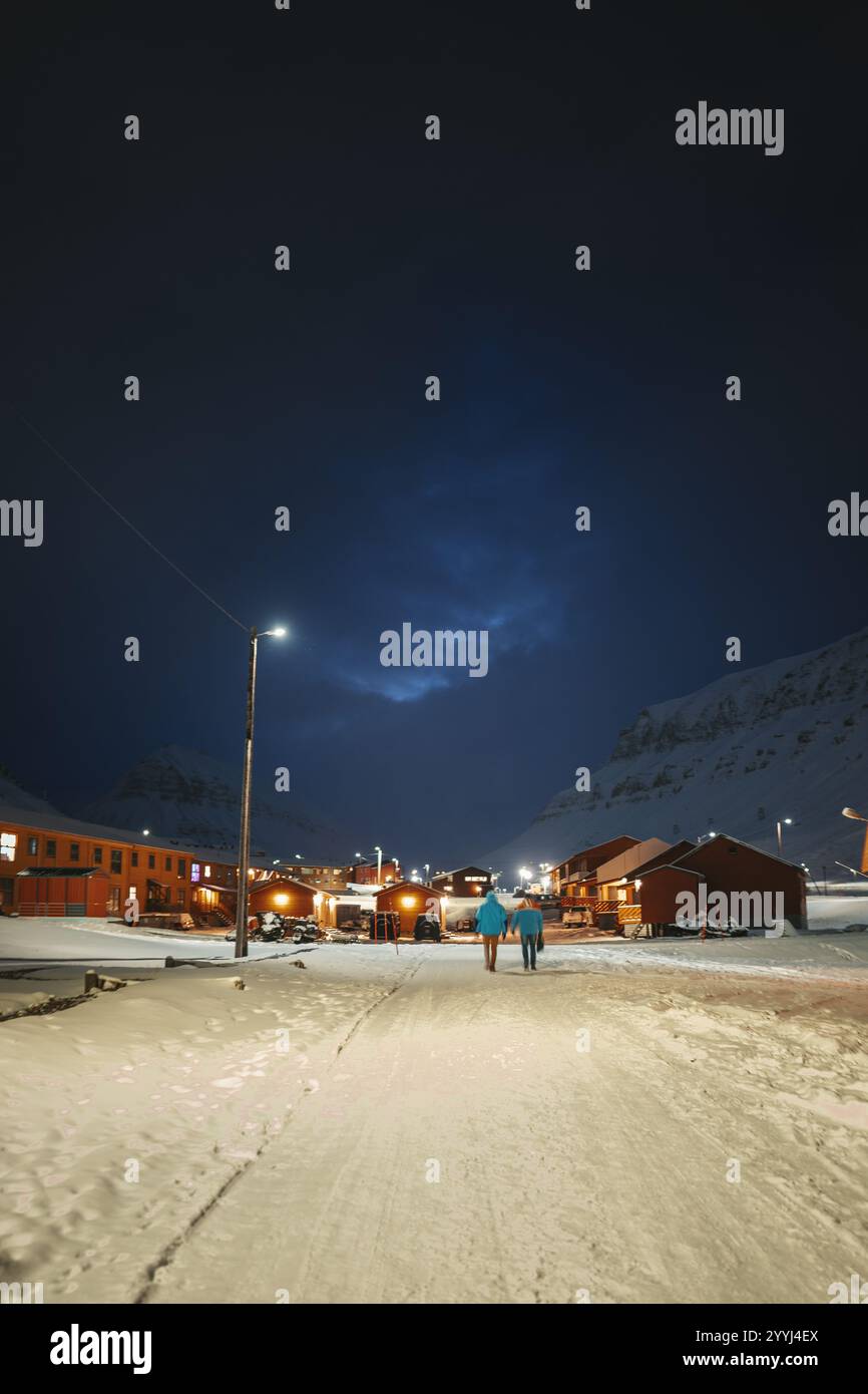 People walking between houses in Longyearbyen, Svalbard in the polar ...
