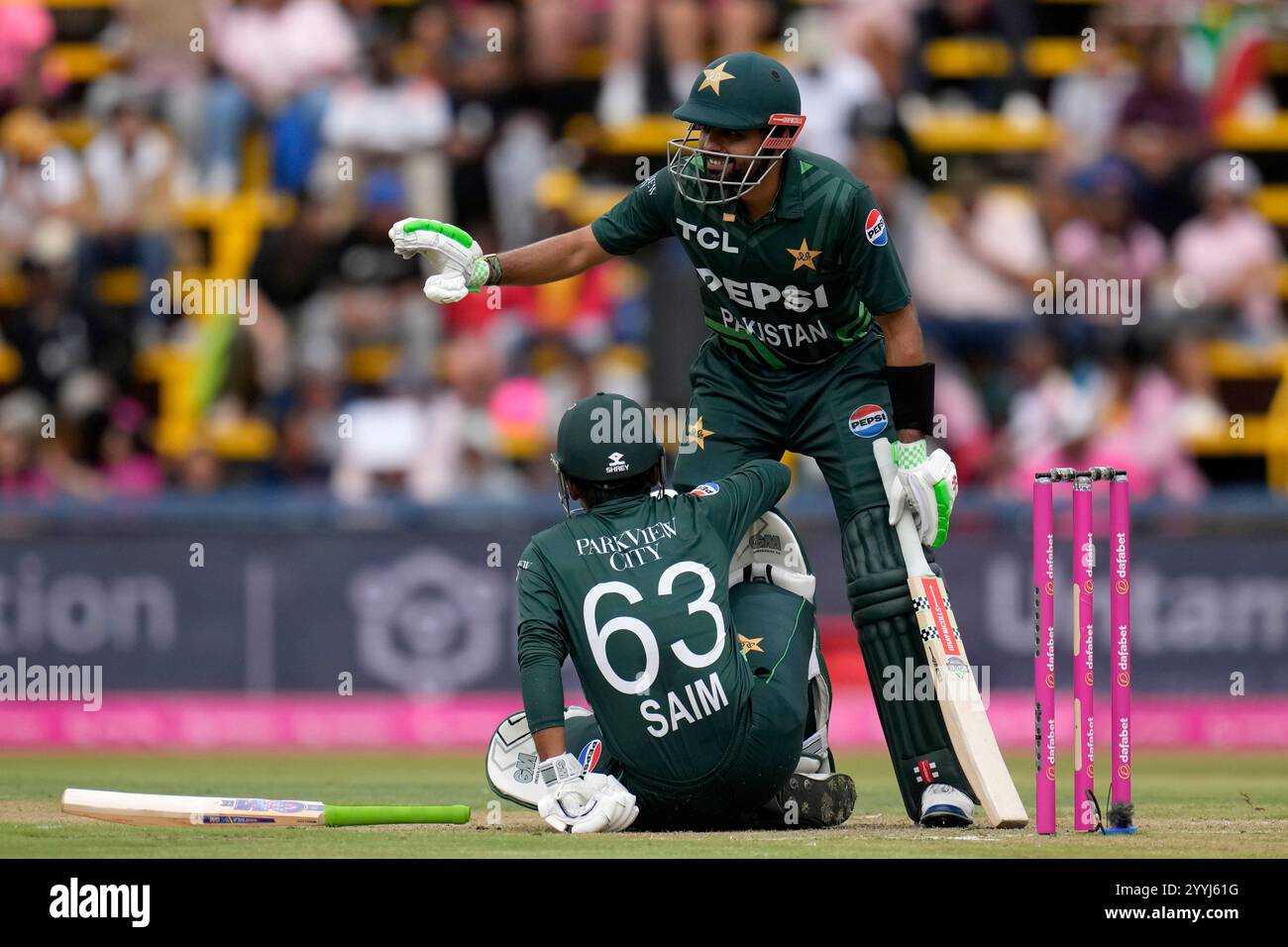 Pakistan's Babar Azam, back, attends his teammate Saim Ayub after being ...