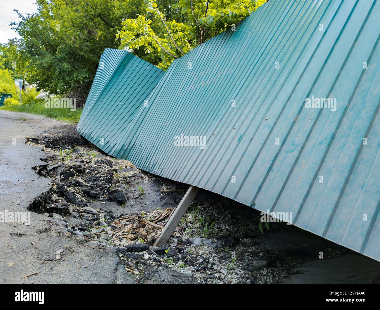 A fragment of a fallen fence made of corrugated sheet metal Stock Photo ...