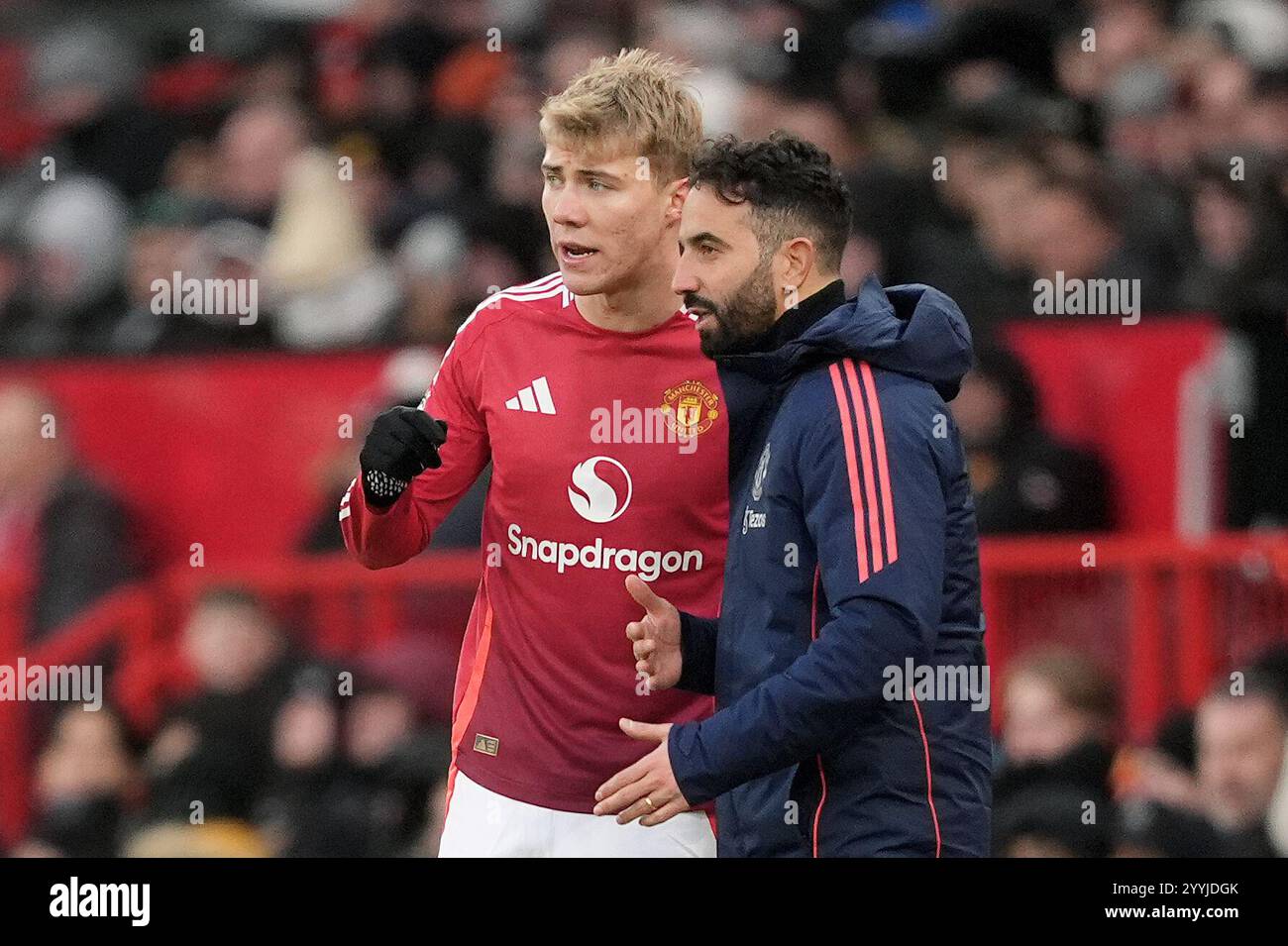 Manchester United manager Ruben Amorim (right) speaks to substitute Manchester United's Rasmus ...