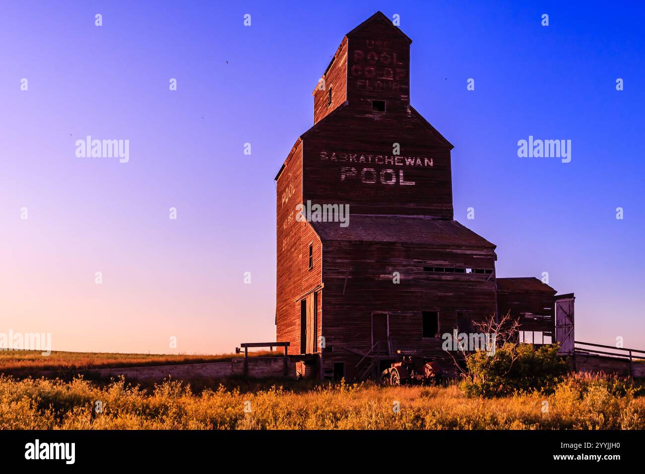 A large, old grain silo with a sign on it that says "Pool House School ...