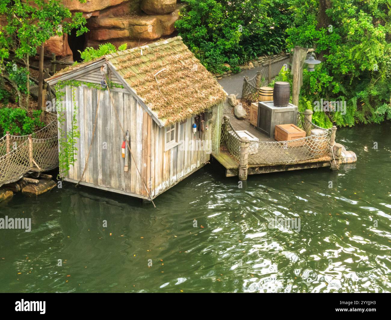 A small wooden shack sits on a dock in the water. The shack is ...