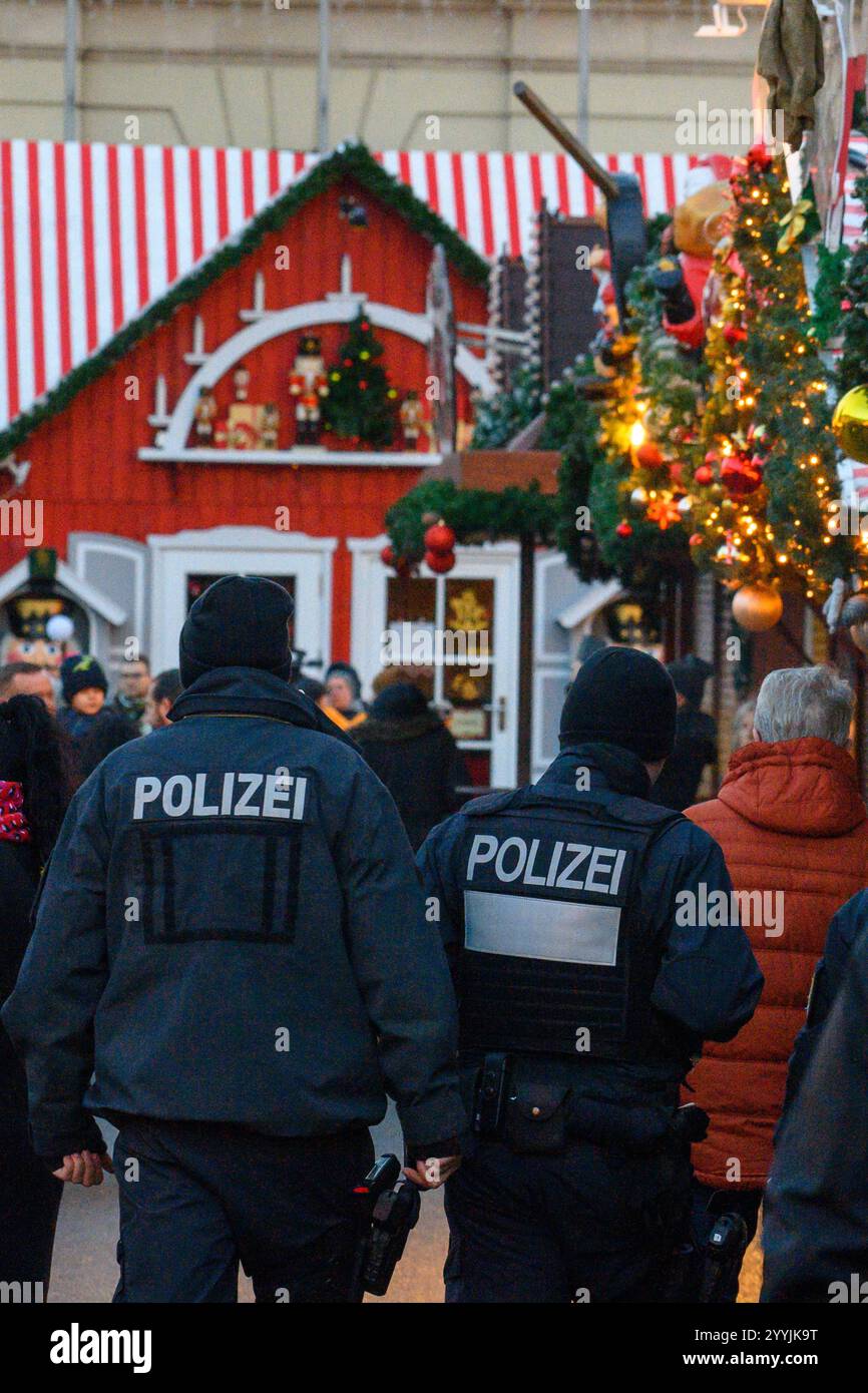 22 December 2024, Saxony-Anhalt, Magdeburg: Police officers and passers ...