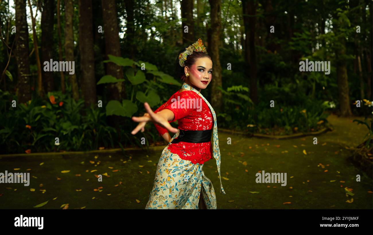 a traditional Sundanese dancer wearing a red costume that reflects the ...