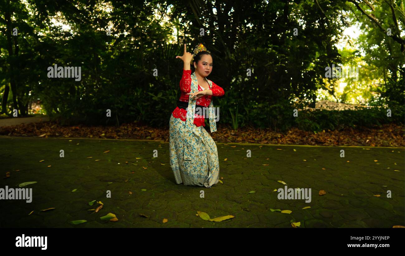 a Javanese dancer wearing a red costume that is thick with legends and ...