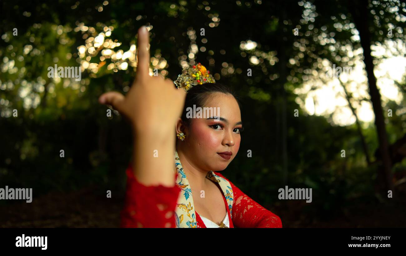 a Javanese dancer wearing a red costume that is thick with legends and ...