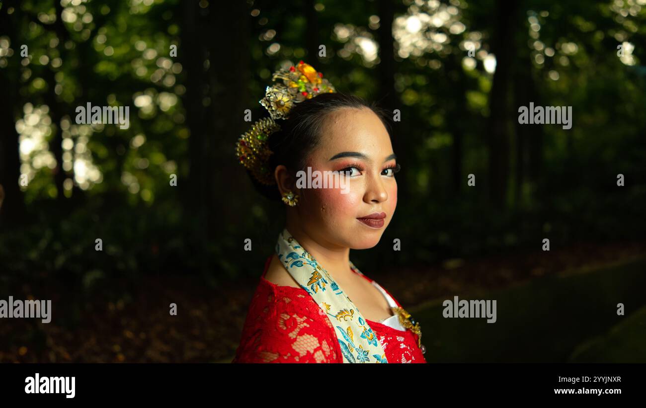 a traditional Sundanese dancer wearing a red costume which is the ...
