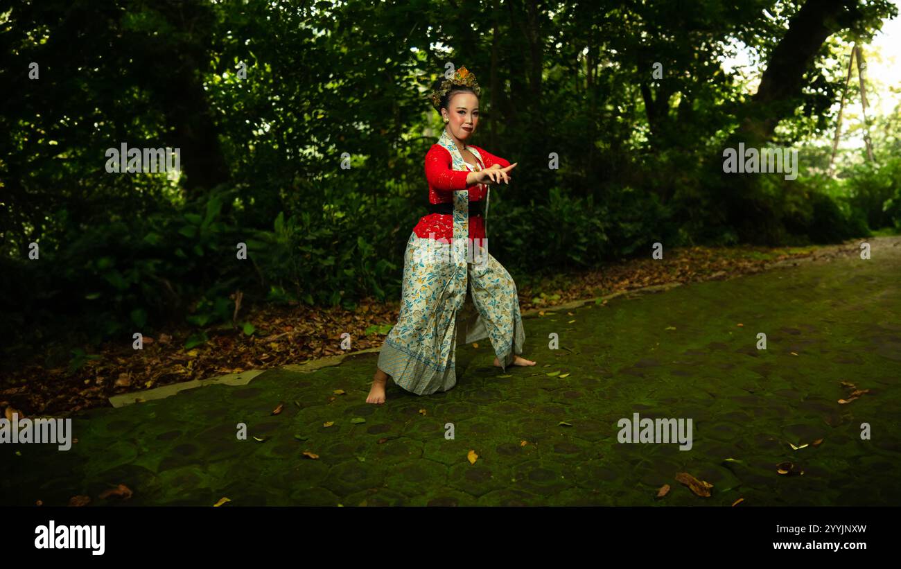 a traditional Sundanese dancer wearing a red costume which is the ...