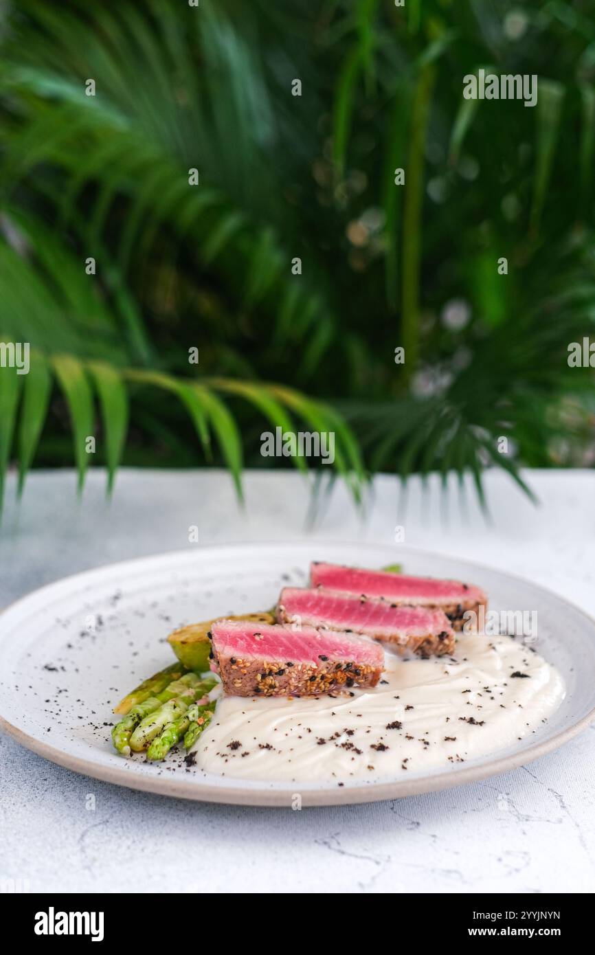 A gourmet dish featuring seared tuna slices, grilled lime, asparagus ...
