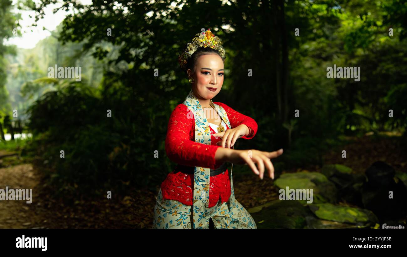 a traditional Sundanese dancer wearing a red costume which is the ...