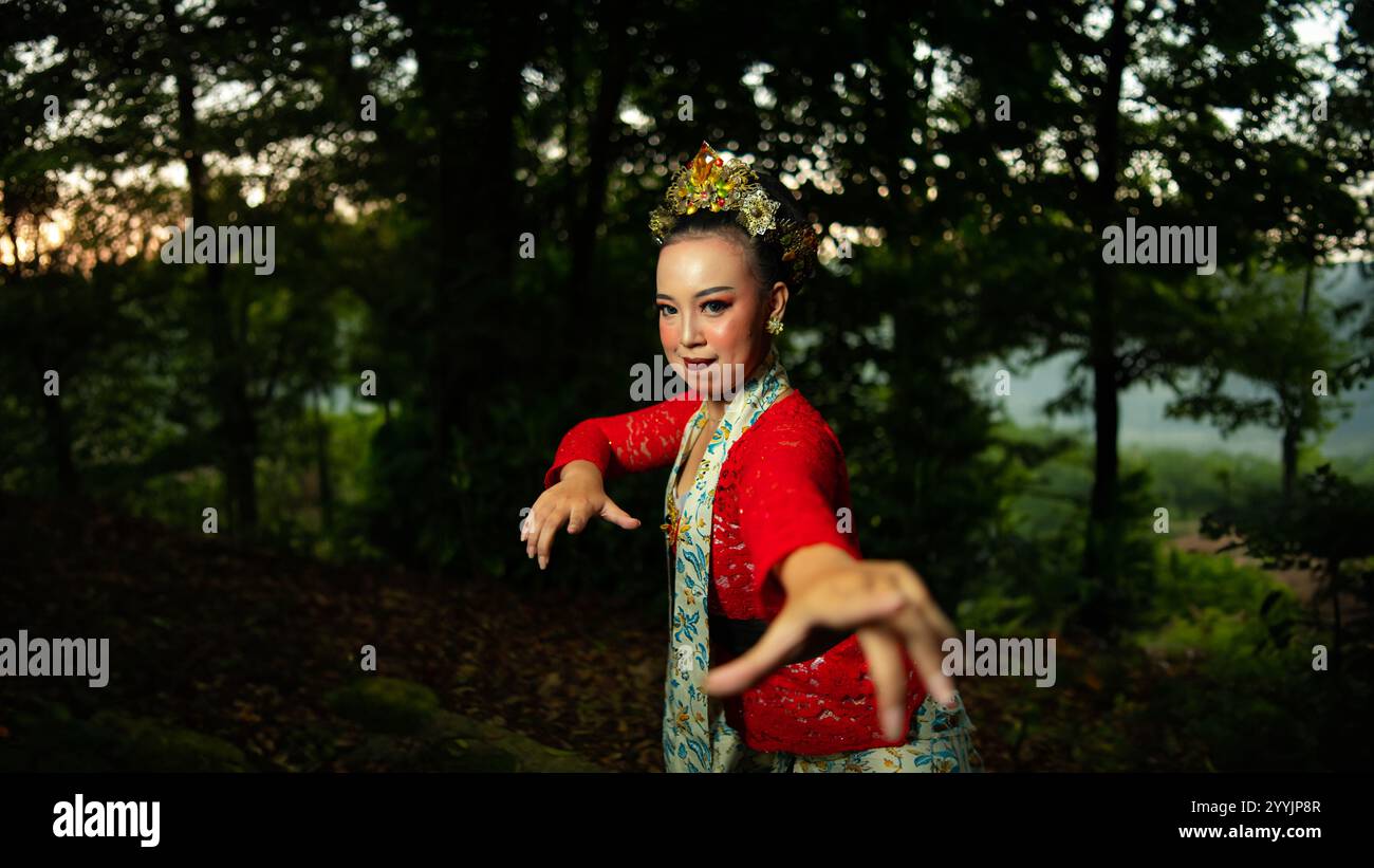 a traditional Balinese dancer wearing a red costume which is a symbol ...