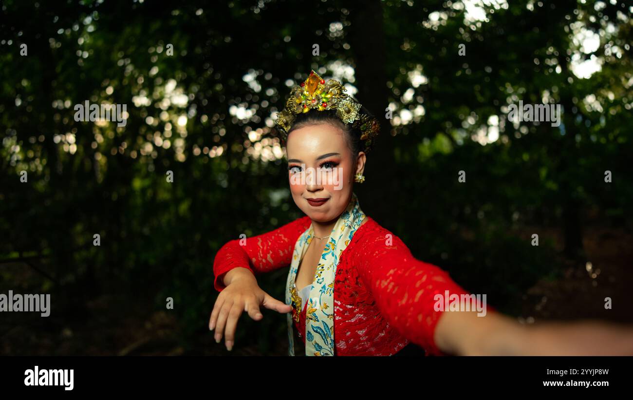a traditional Balinese dancer wearing a red costume which is a symbol ...