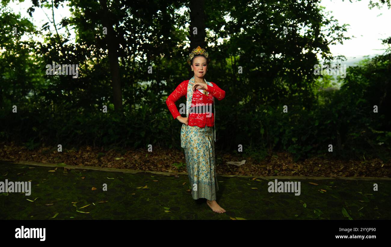 a traditional Balinese dancer wearing a red costume which is a symbol ...