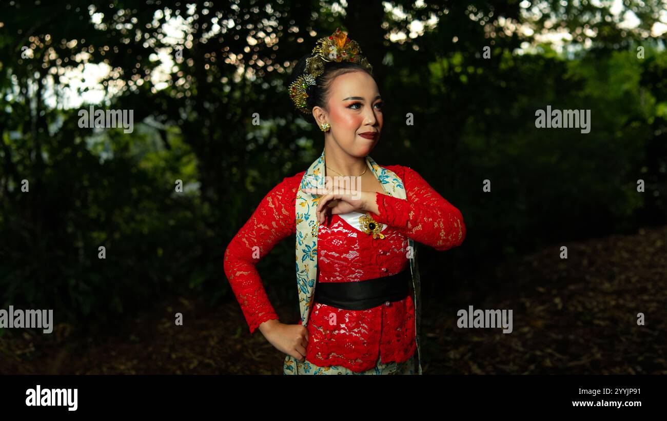 a traditional Balinese dancer wearing a red costume which is a symbol ...