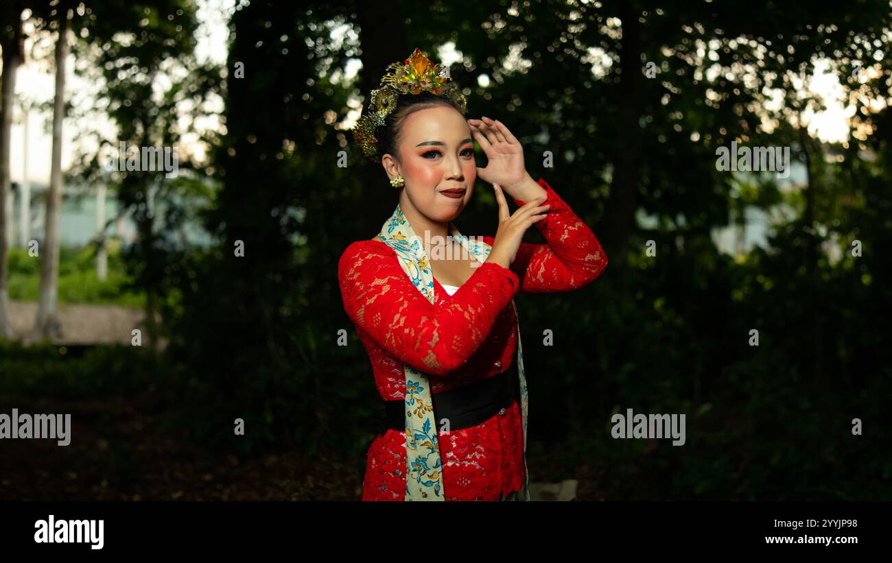a traditional Balinese dancer wearing a red costume which is a symbol ...