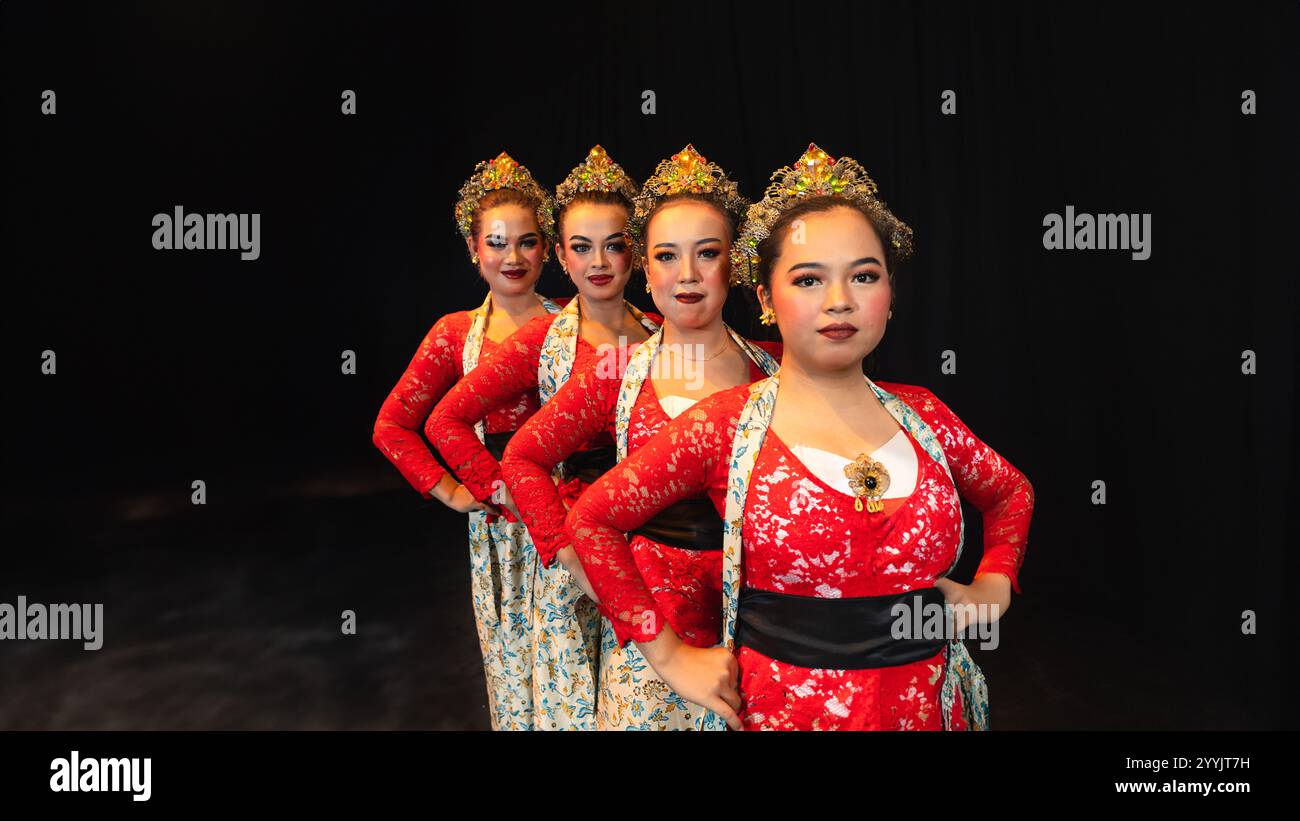 a group of Javanese dancers wearing uniform red costumes creates visual ...