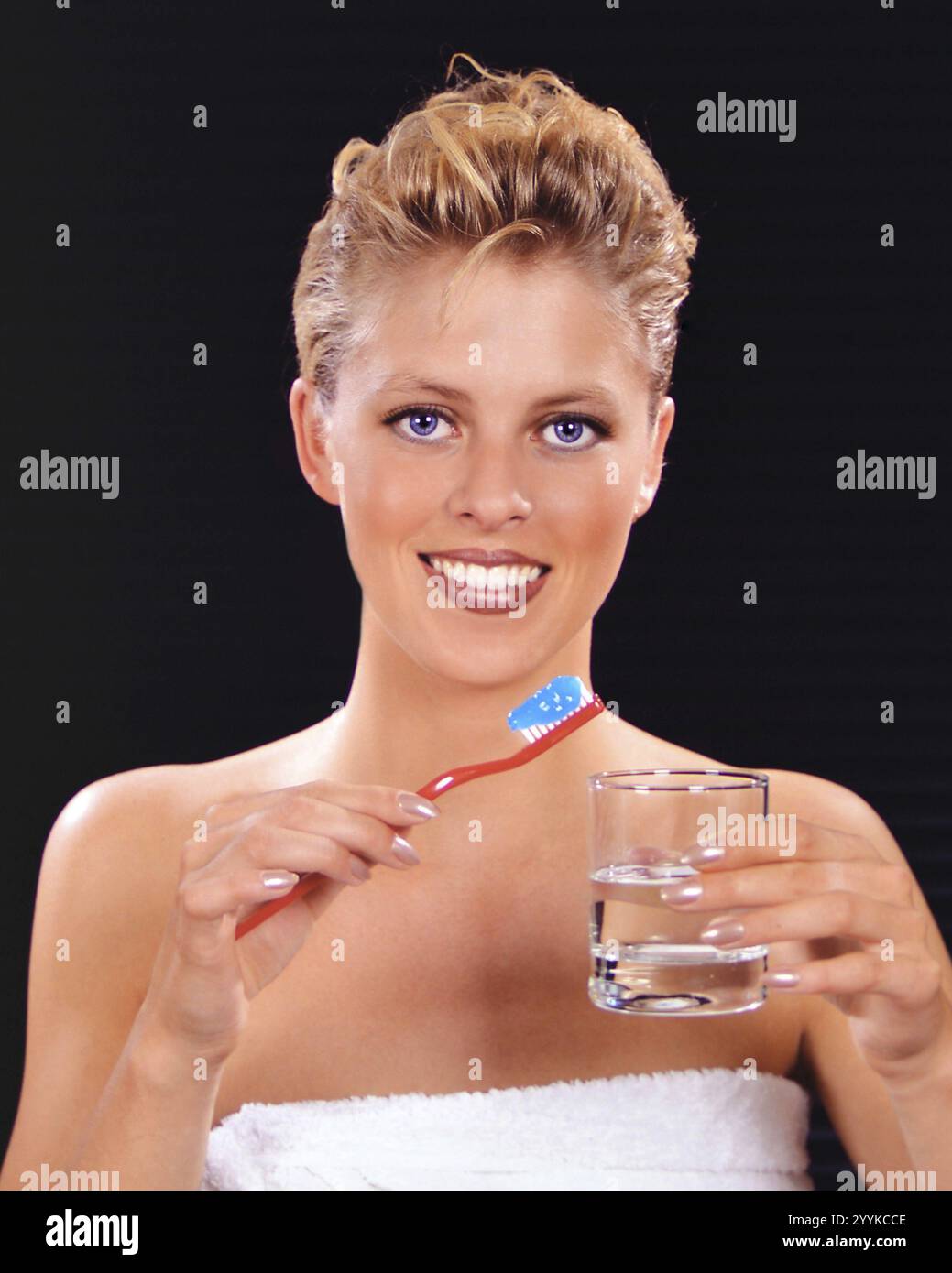 A blonde woman, 25 years old, brushing her teeth in the bathroom in the ...
