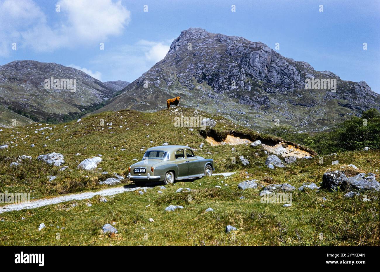 Historical photo of an old Rover car parked on a gravel road with a ...