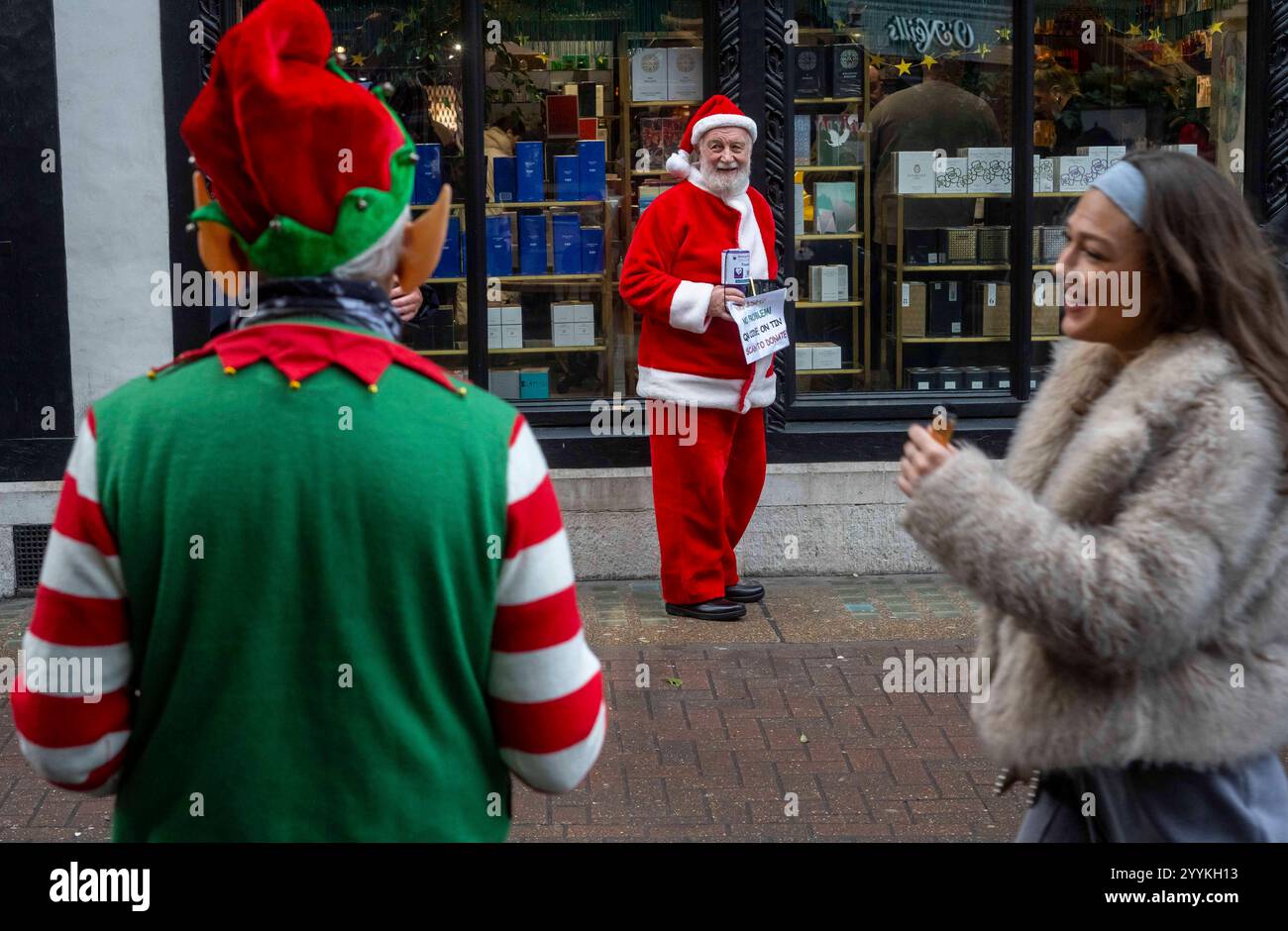 © Jeff Moore Santa and one of his elf cheering up Christmas shoppers on ...