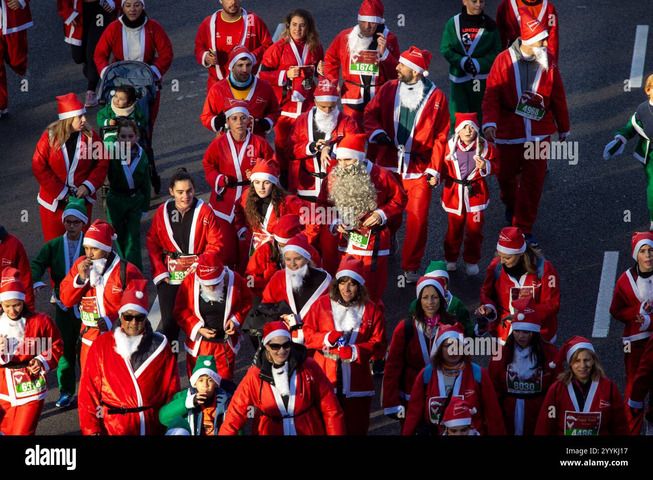 Hundreds of runners dressed as Santa Claus run through a street in the ...