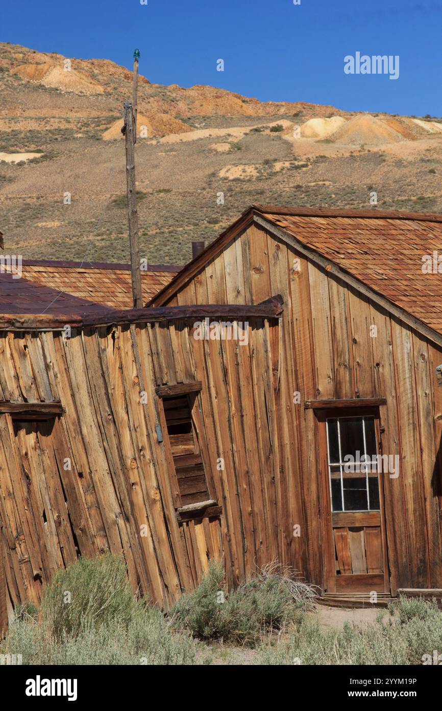 A house with a crooked roof and a crooked door. The house is old and ...