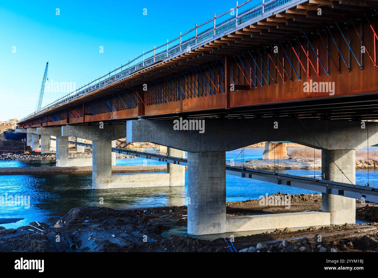 A bridge is being built over a body of water. The bridge is made of ...