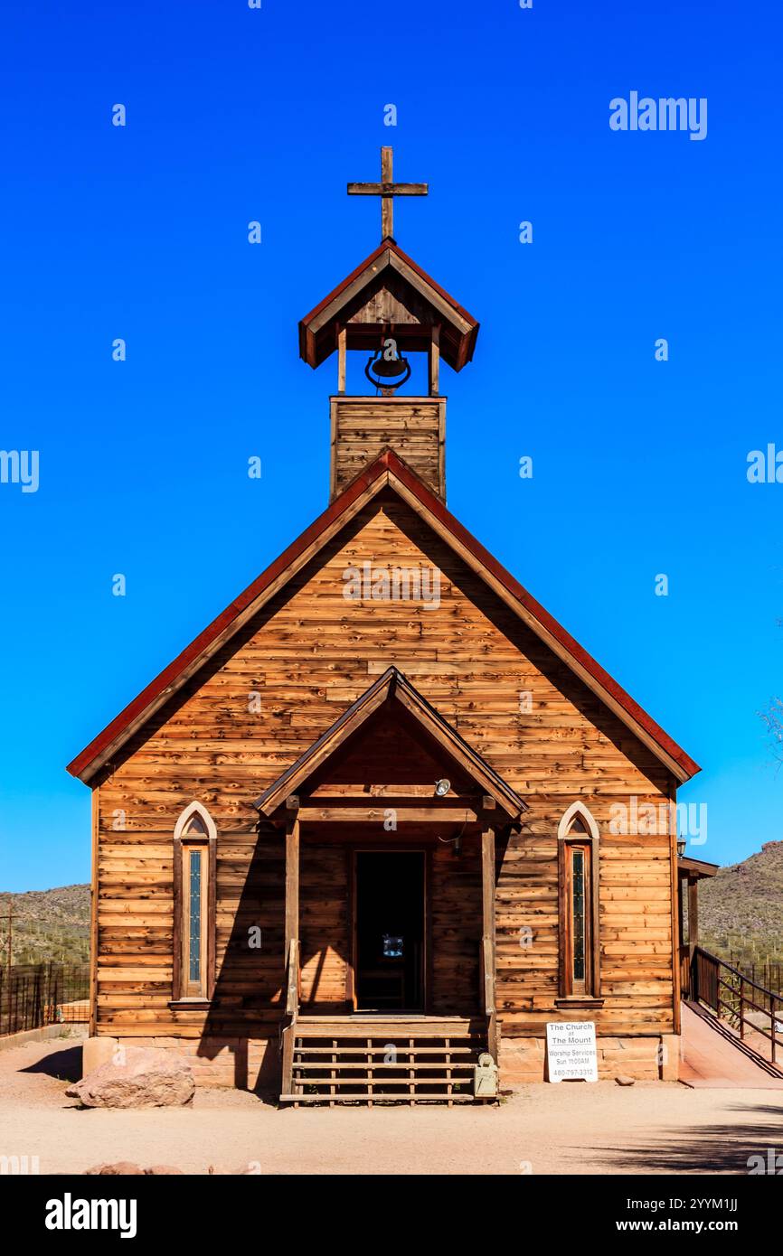 A small church with a bell tower and a cross on top. The church is ...