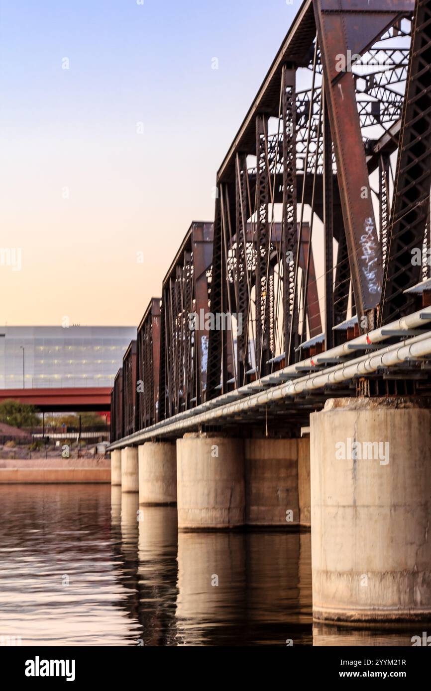A bridge spans a river with a train passing underneath. The bridge is ...