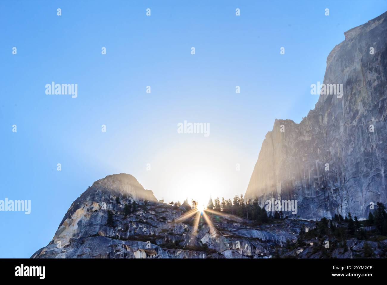 A mountain range with a sun shining on it. The sun is bright and the ...