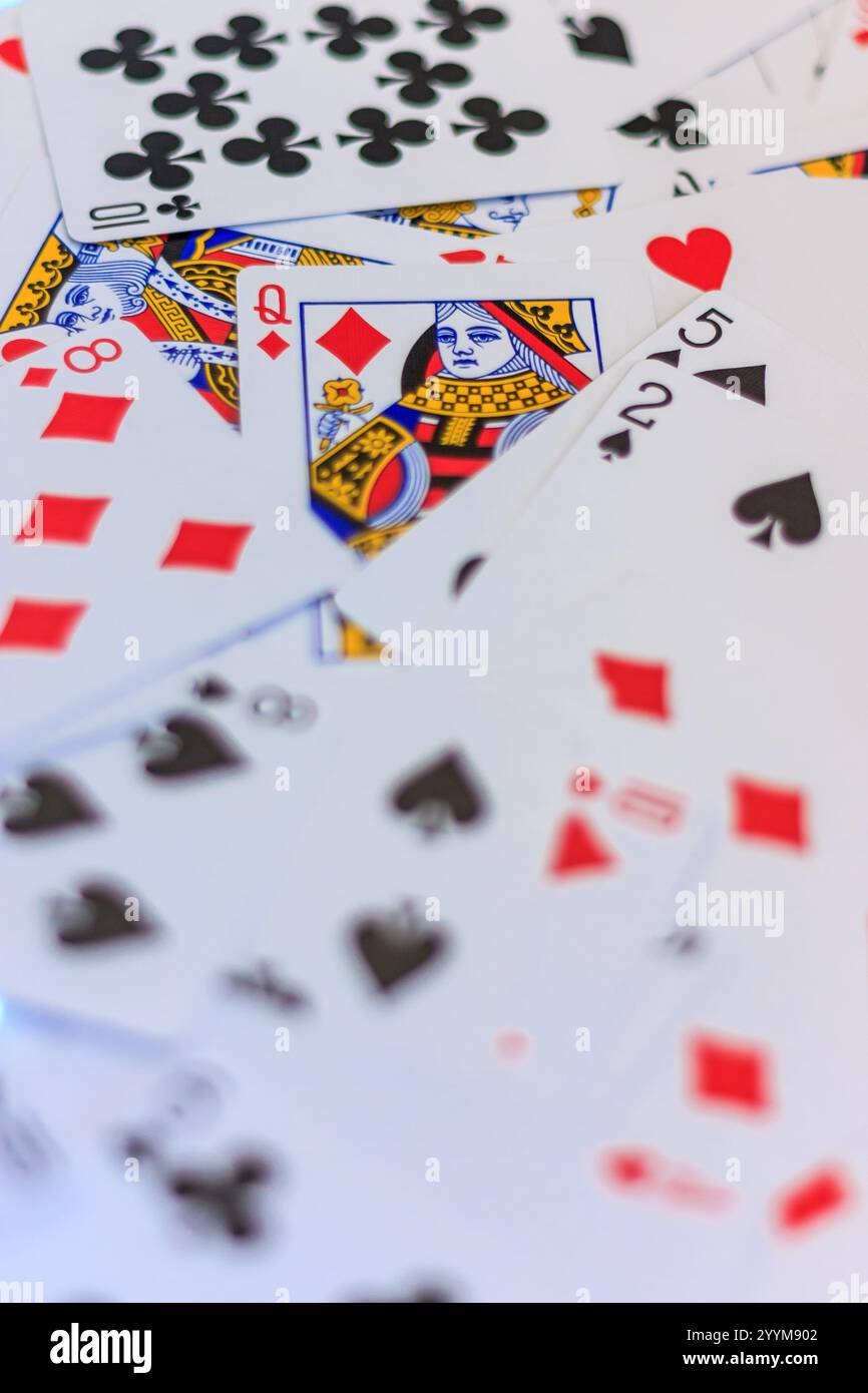 A pile of playing cards with a queen on top. The cards are red and ...