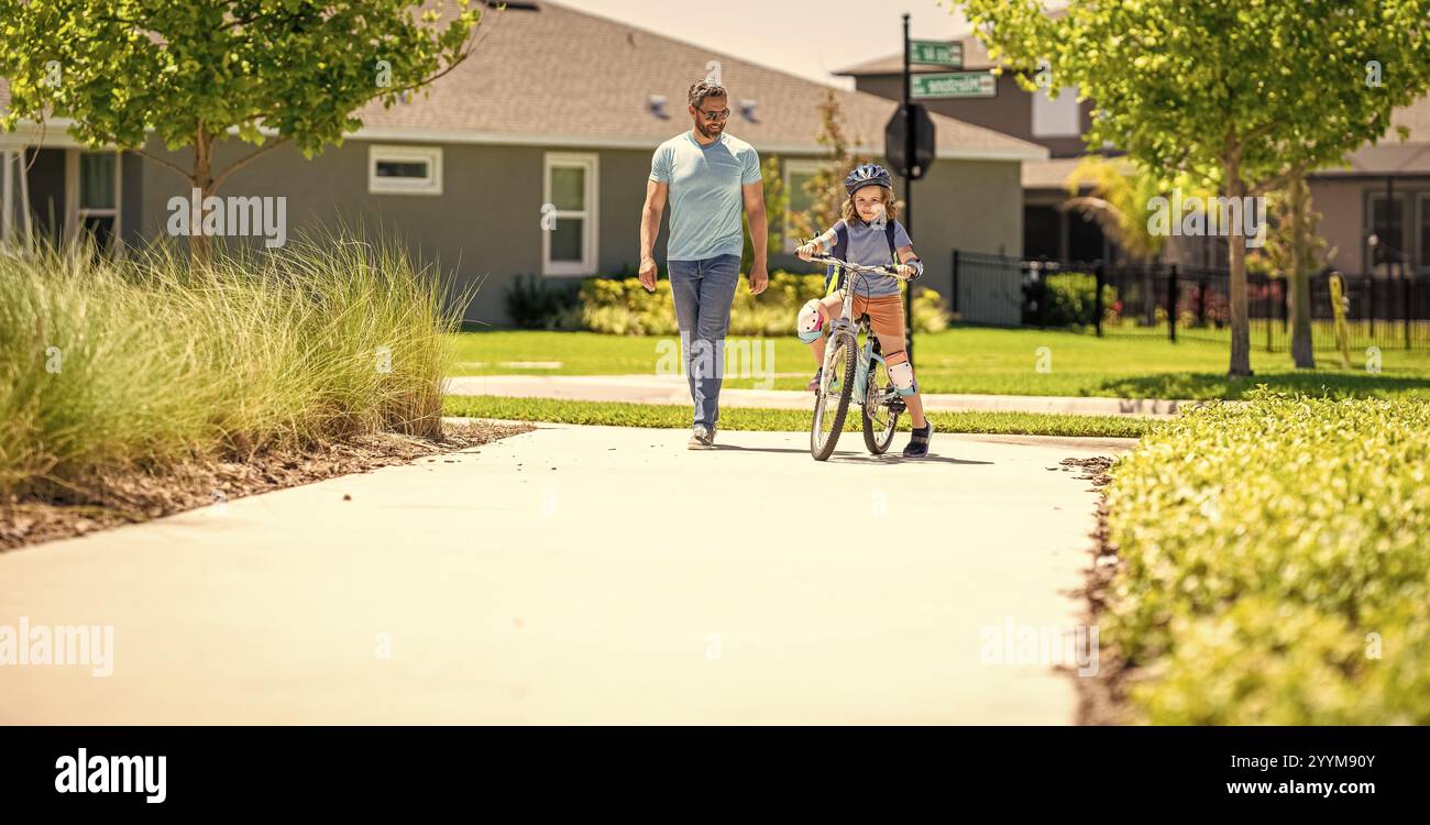 dad guiding his son first bike ride. Pedaling together with joy. dad and son enjoying fun bike ...