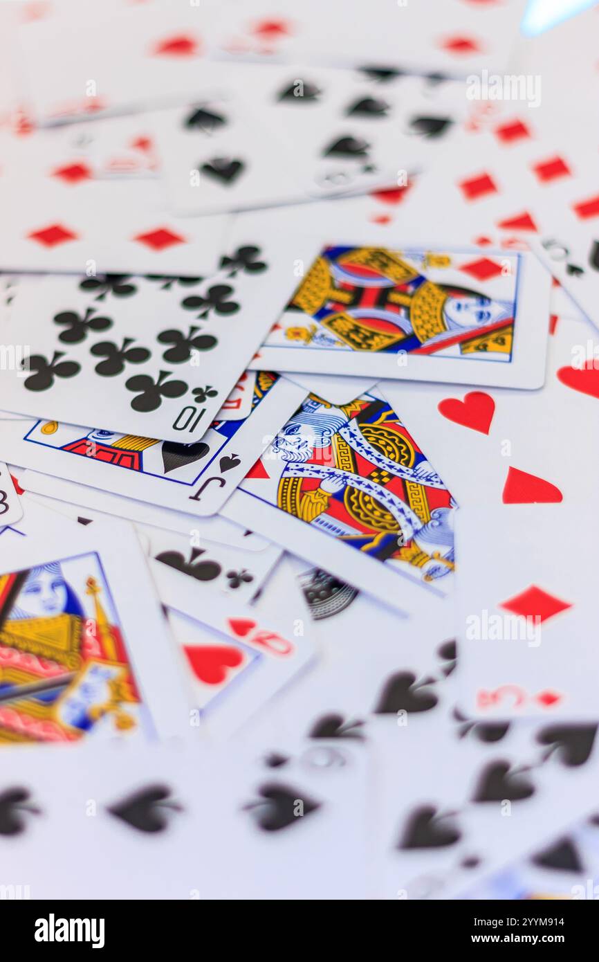 A pile of playing cards with a queen and a king on top. The cards are ...