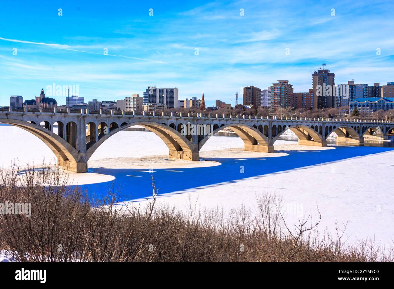 A bridge spans a river with a blue tint. The city below is bustling ...