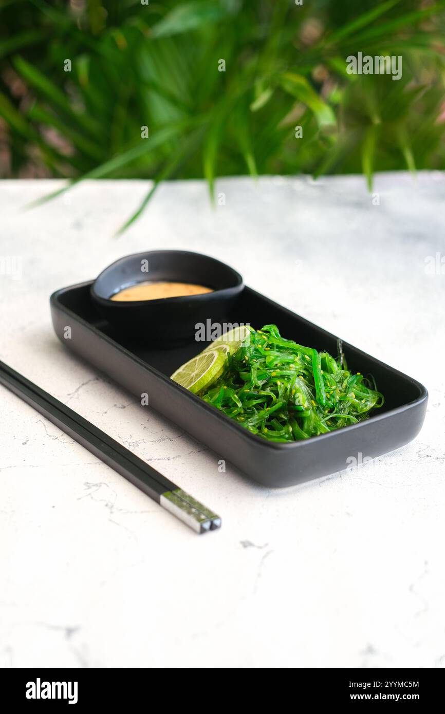 A sophisticated presentation of vibrant green seaweed salad served in a ...