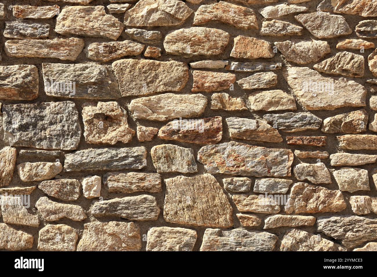 a yellow beige sand color stone brick vertical wall Stock Photo - Alamy