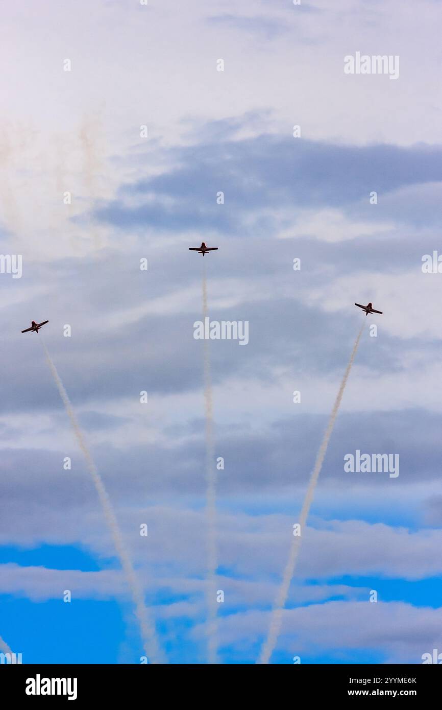 Three fighter jets are flying in formation in the sky. The clouds are ...