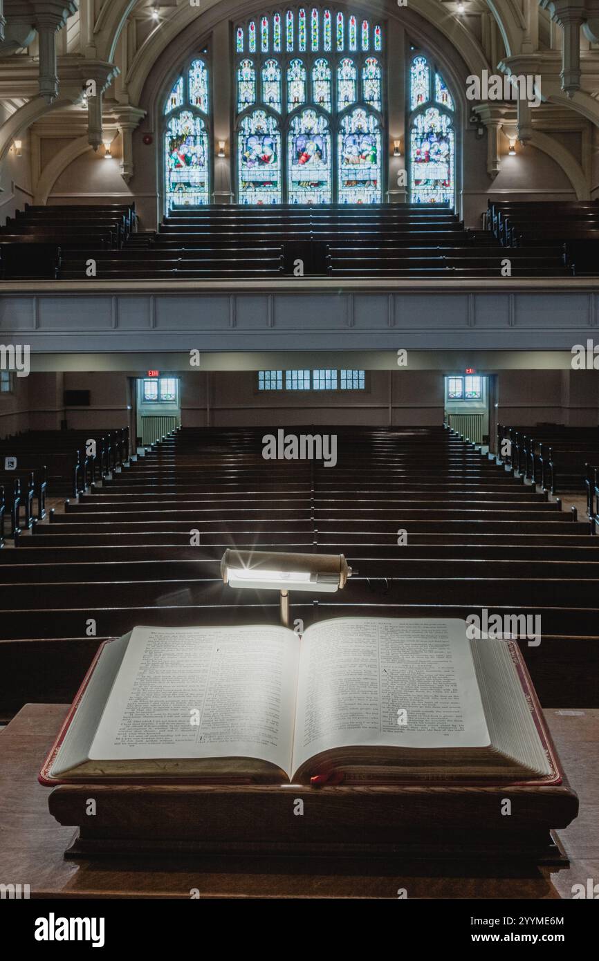 A large open book is on a table in a church. The book is open to a page ...