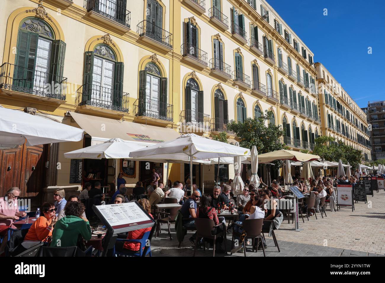 People sitting outside various restaurants on Plaza de la Merced in ...