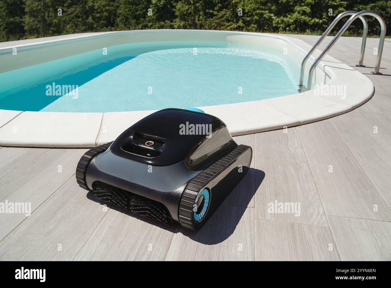 An advanced pool cleaning robot in front of a backyard swimming pool ...