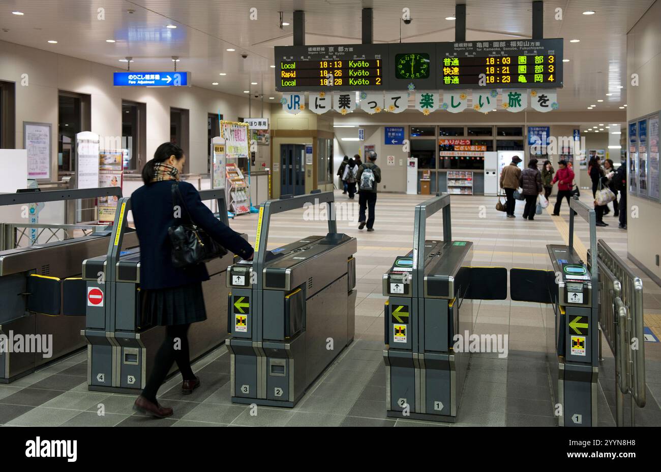 A woman swipes her rail pass card as she passes through an electronic ...