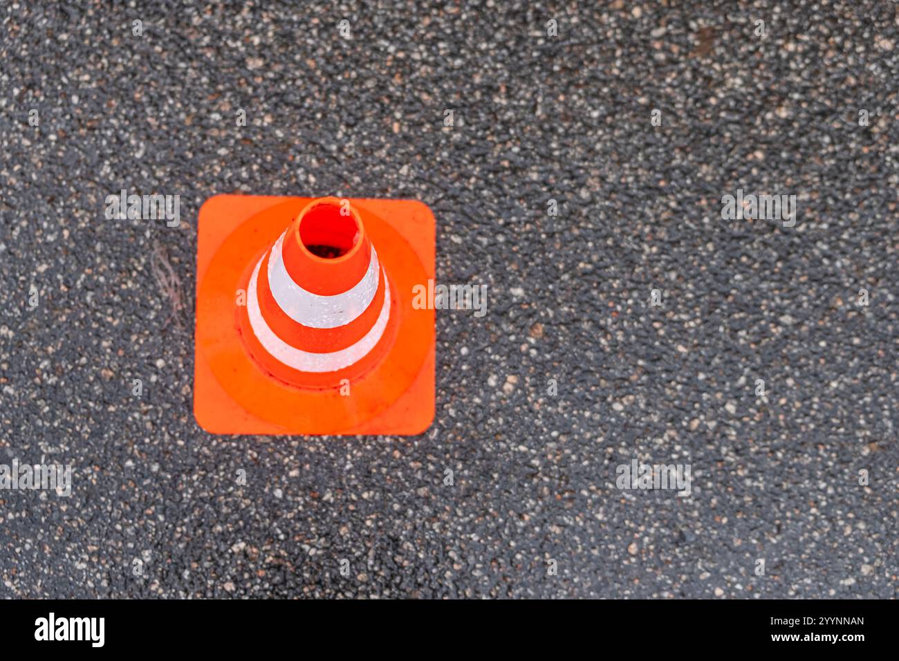 traffic cone, white and orange stripes on gray asphalt, copy space ...
