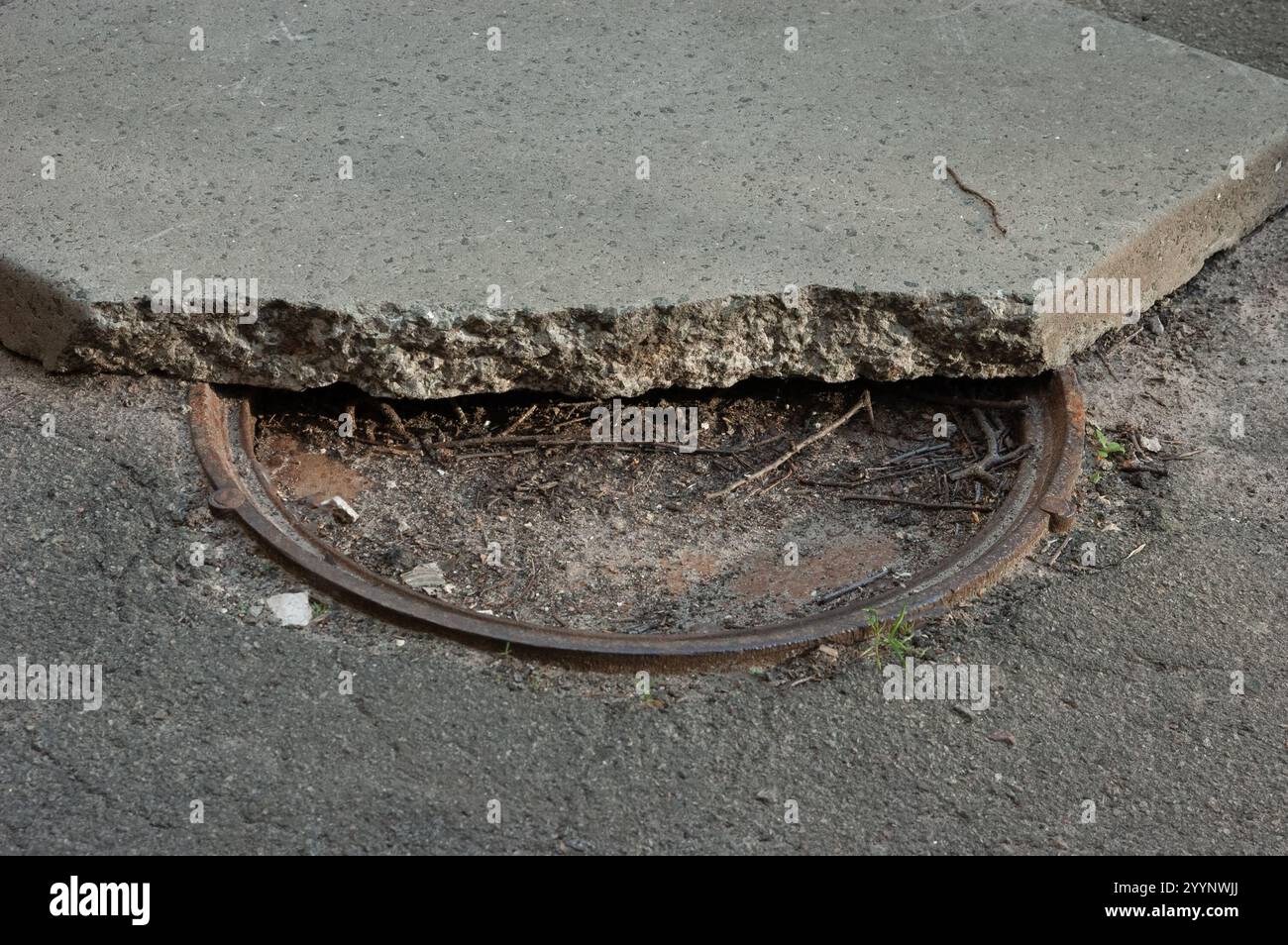 a concrete slab covers an old rusty sewer manhole Stock Photo - Alamy