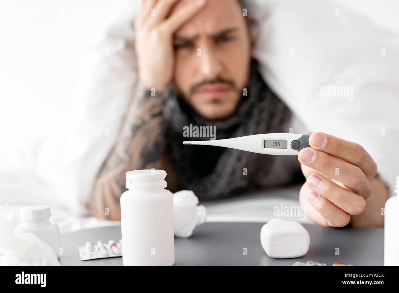 Coronavirus and influenza symptoms. Sick guy showing thermometer with ...