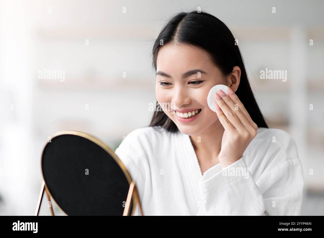 Beautiful asian woman cleaning her face with toner Stock Photo - Alamy